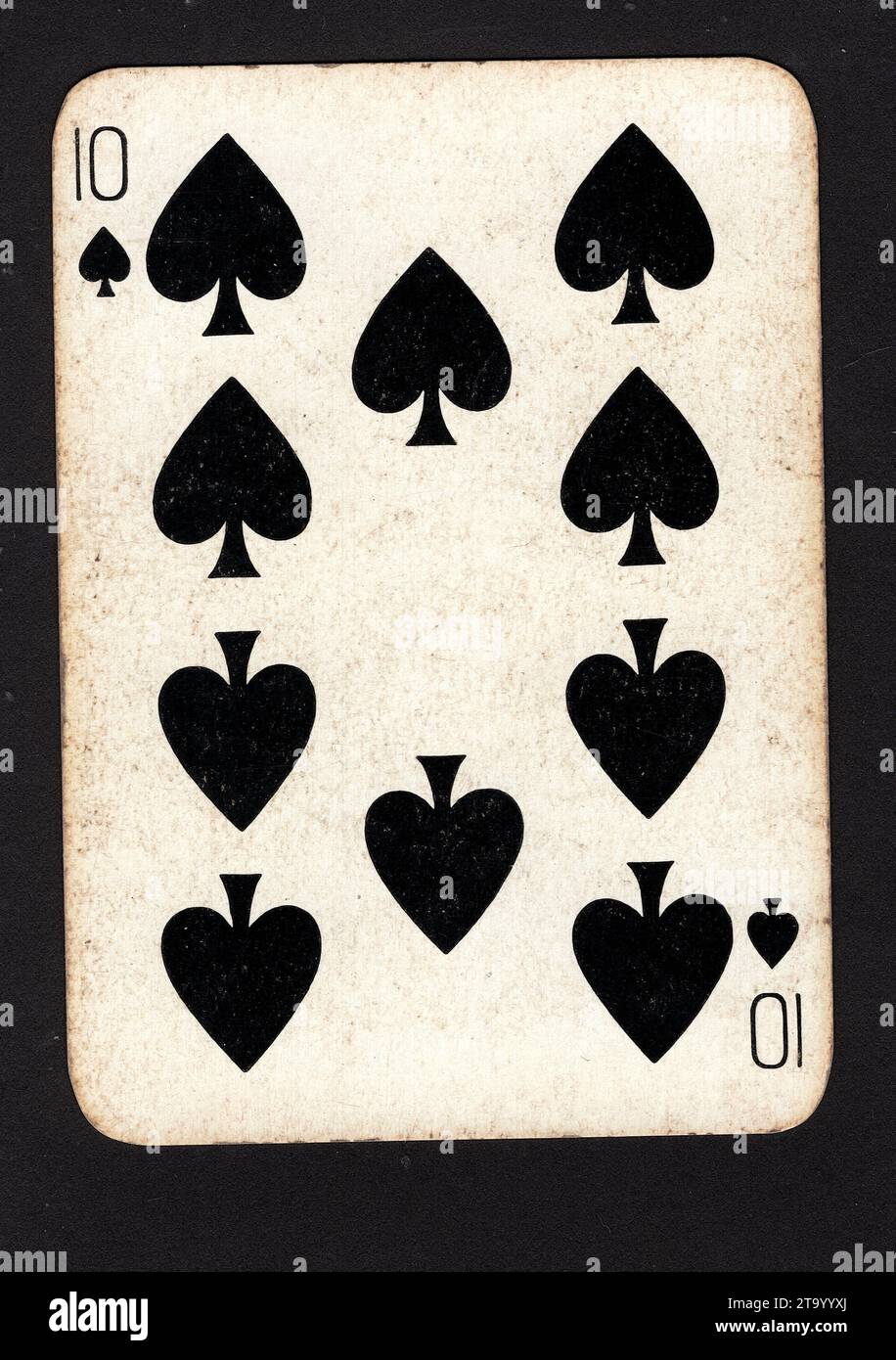A vintage ten of spades playing card isolated on a black background ...
