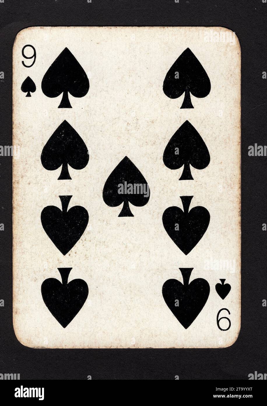 A vintage nine of spades playing card isolated on a black background ...
