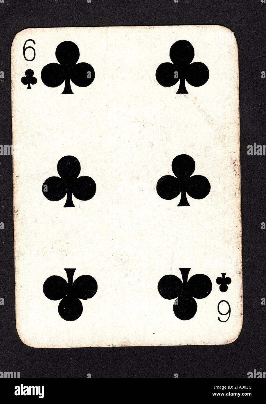 A vintage six of clubs playing card isolated on a black background ...