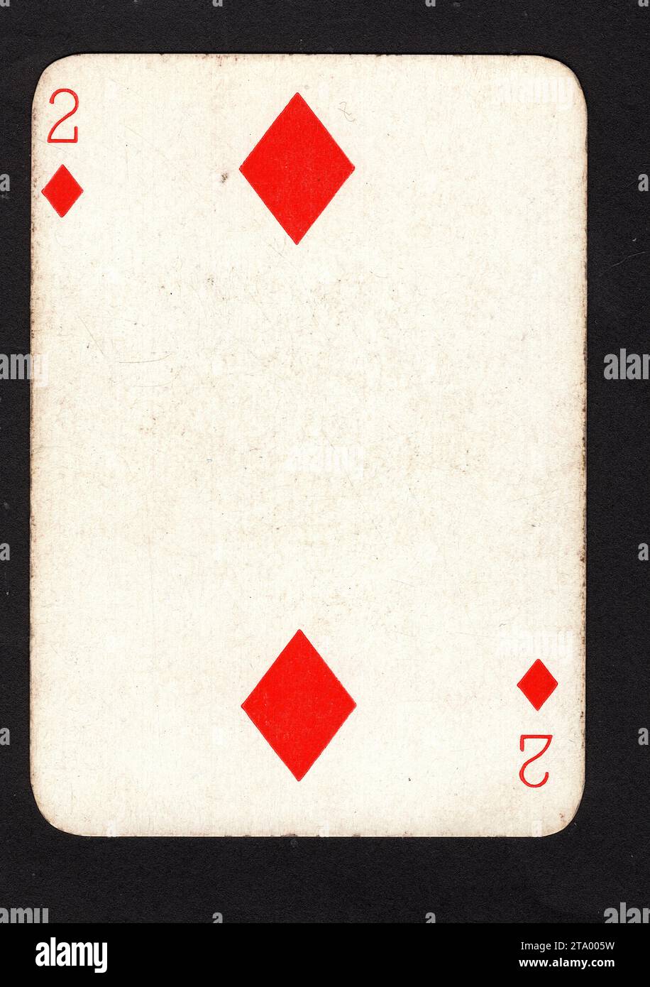 A vintage two of diamonds playing card isolated on a black background ...