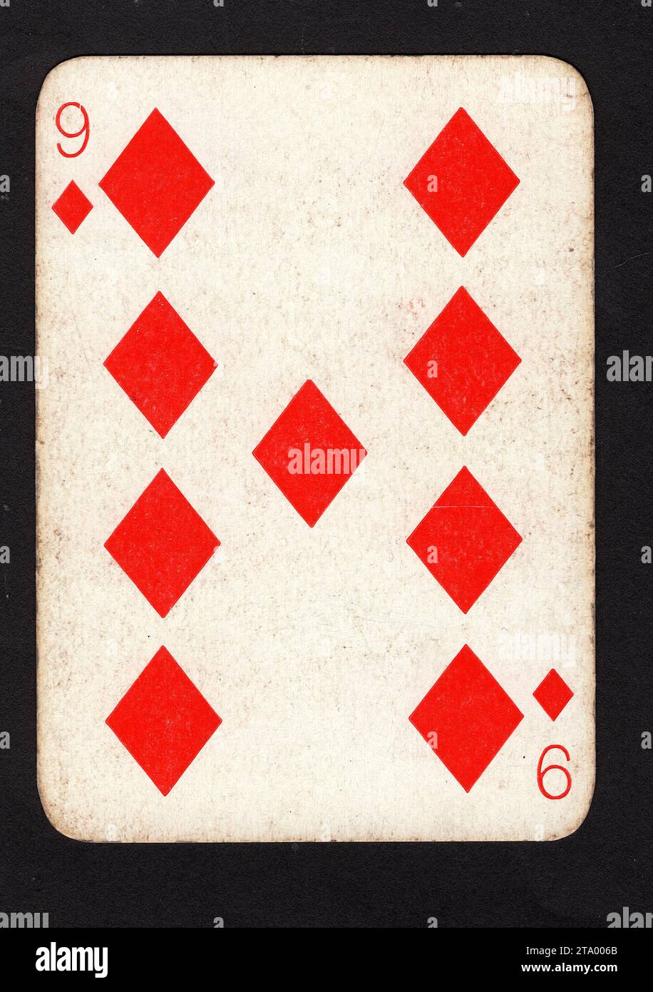 A vintage nine of diamonds playing card isolated on a black background ...