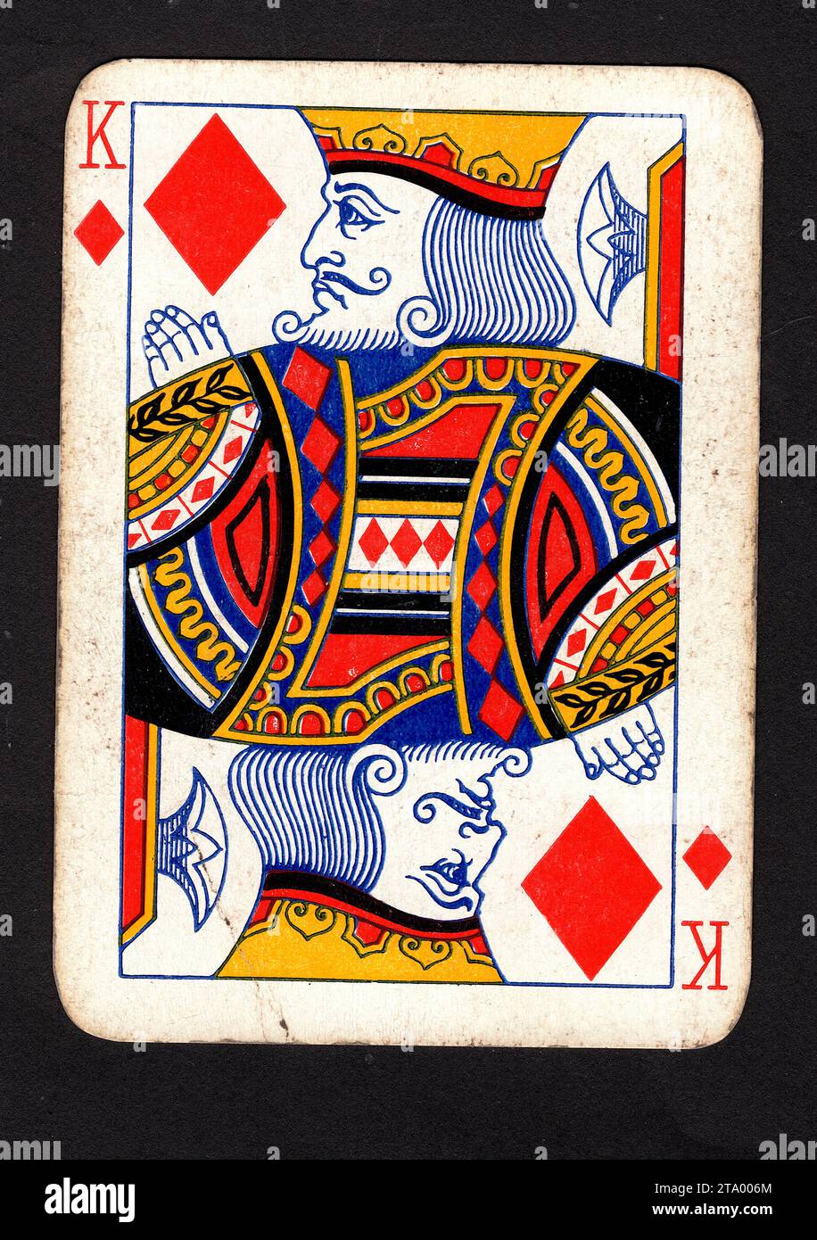 A vintage king of diamonds playing card isolated on a black background ...