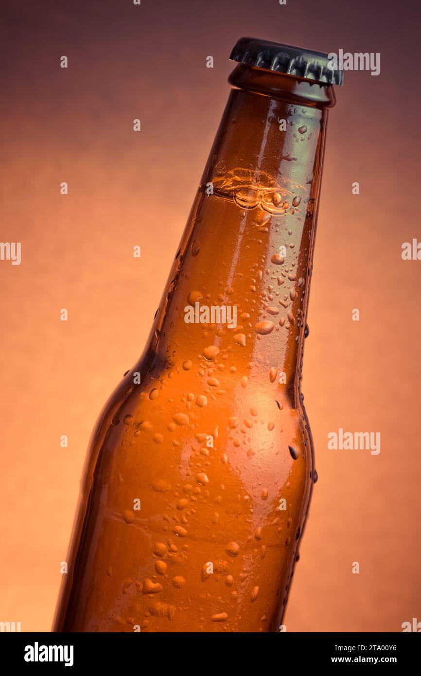 fresh cold beer ale bottle with drops and stopper on warm background ...
