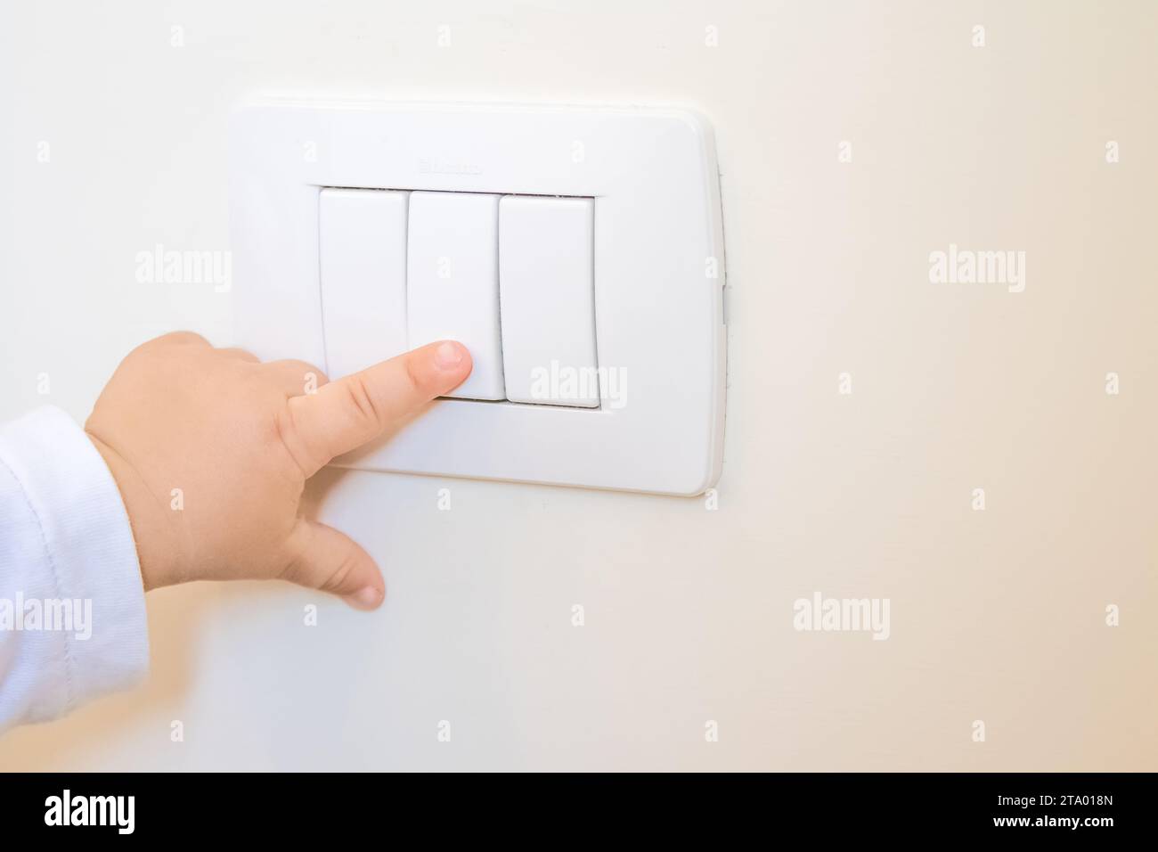 adorable little boy child turning on the white light-switch with his ...