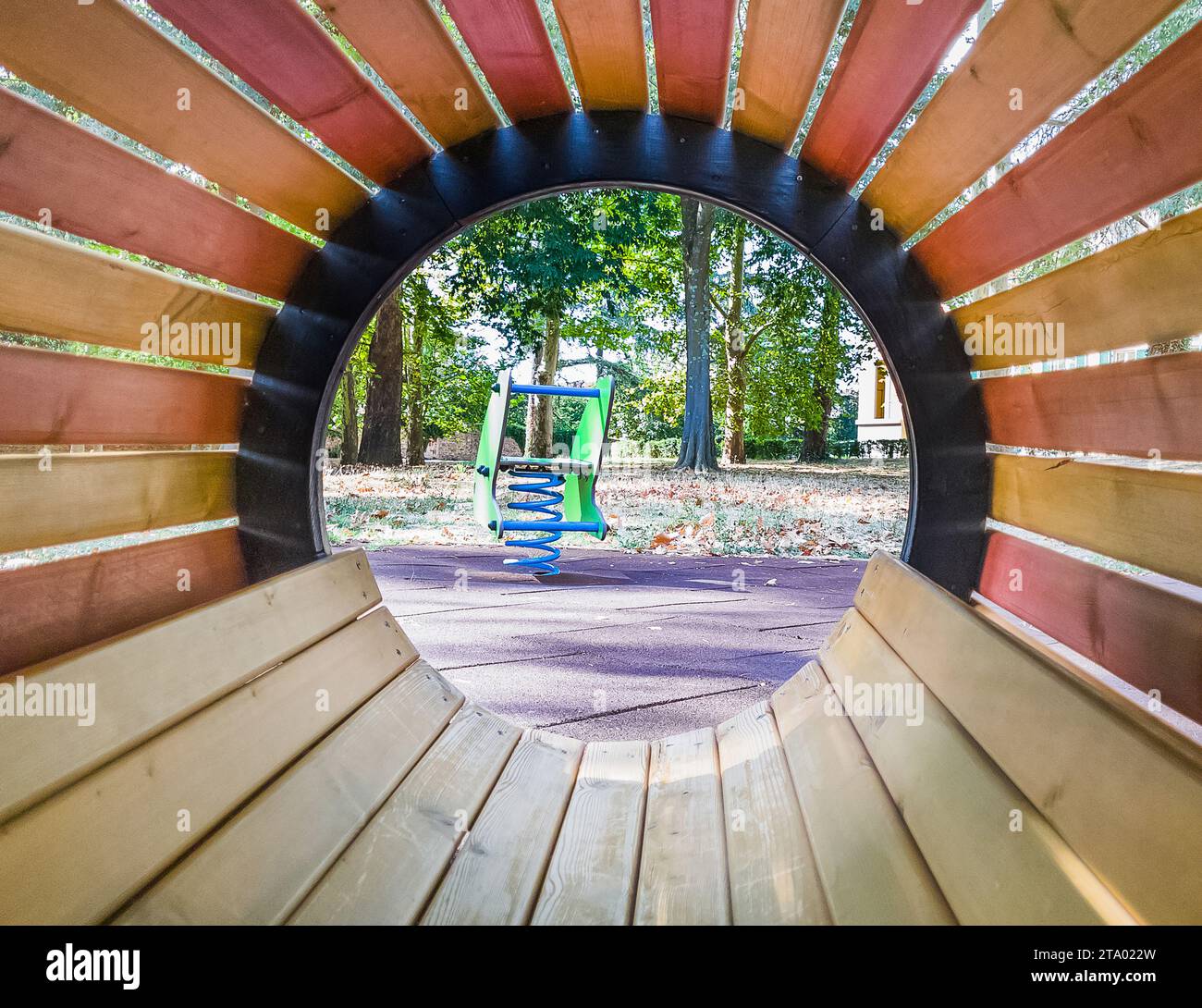 see through empty wood tube at playground for child, on green meadow ...