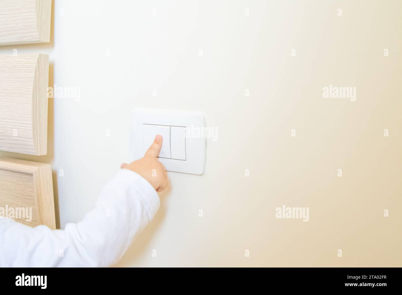 adorable little boy child turning on the white light-switch with his ...