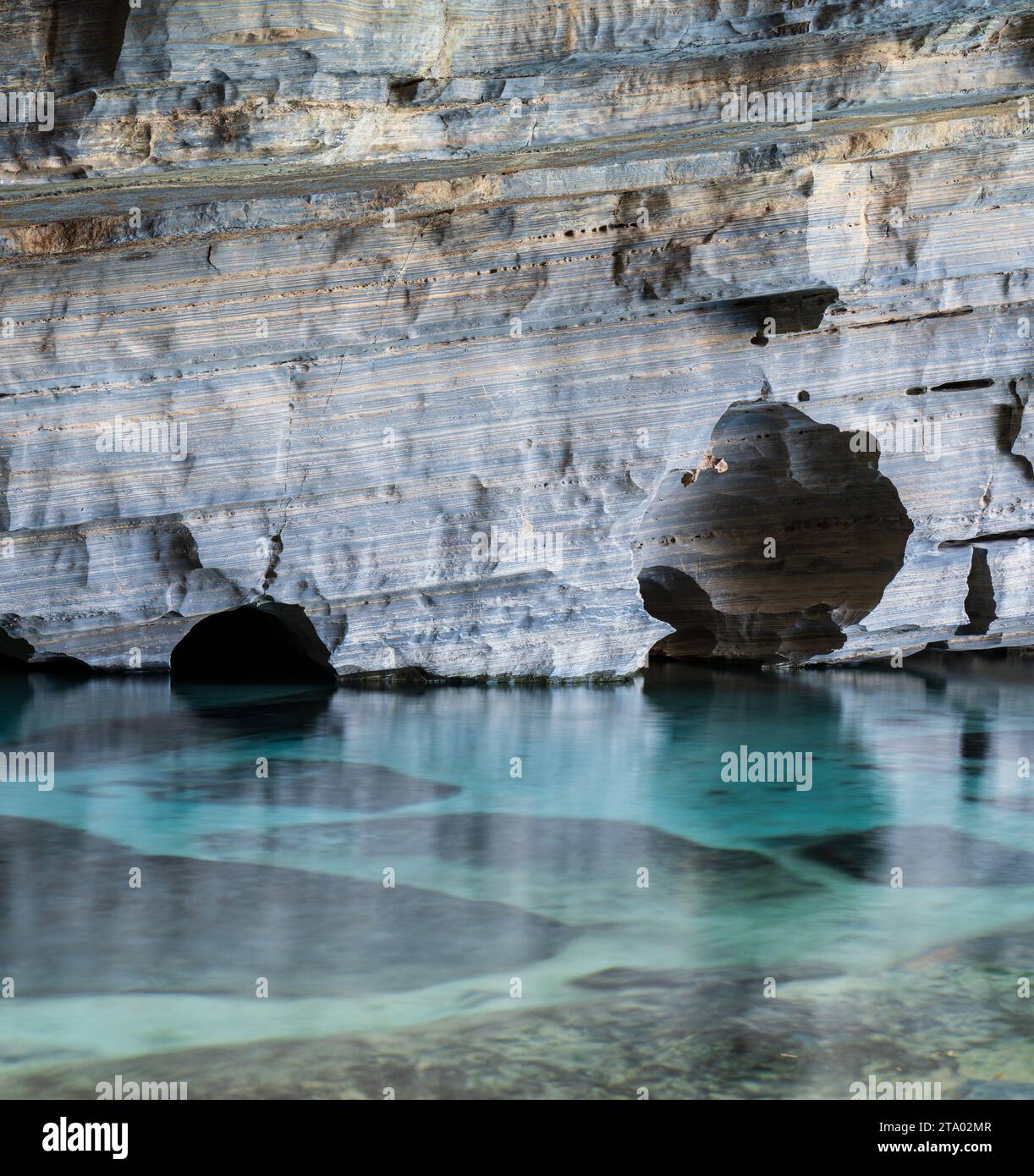 Vertical Cliff Layered Texture Over Crystal Blue Waters Stock Photo - Alamy