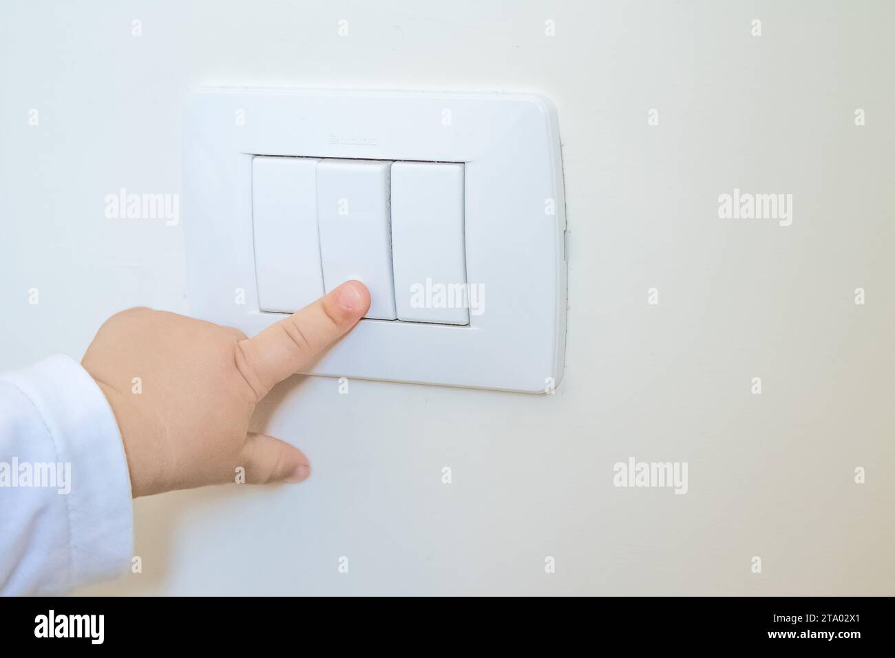 adorable little boy child turning on the white light-switch with his ...