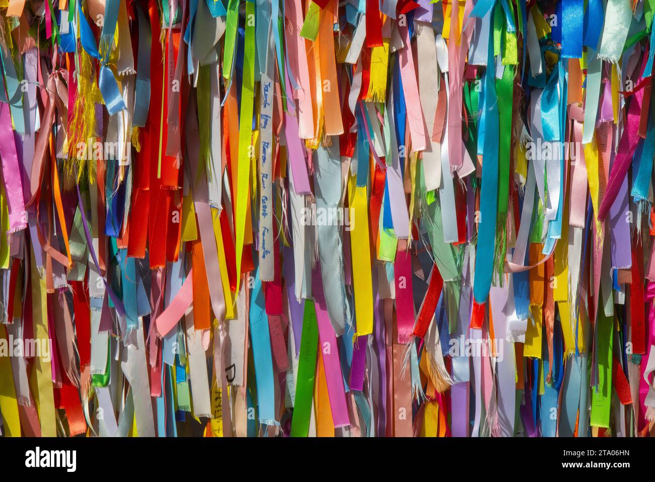 A vibrant wall composed of multiple colored streamers affixed to a ...