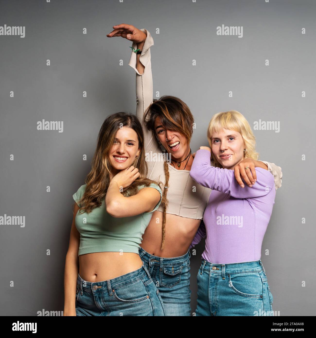 Three happy friends share a close moment, their playful poses ...