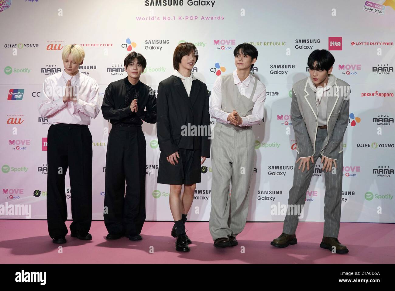 Members of TOMORROW X TOGETHER pose for photos on the red carpet of the ...