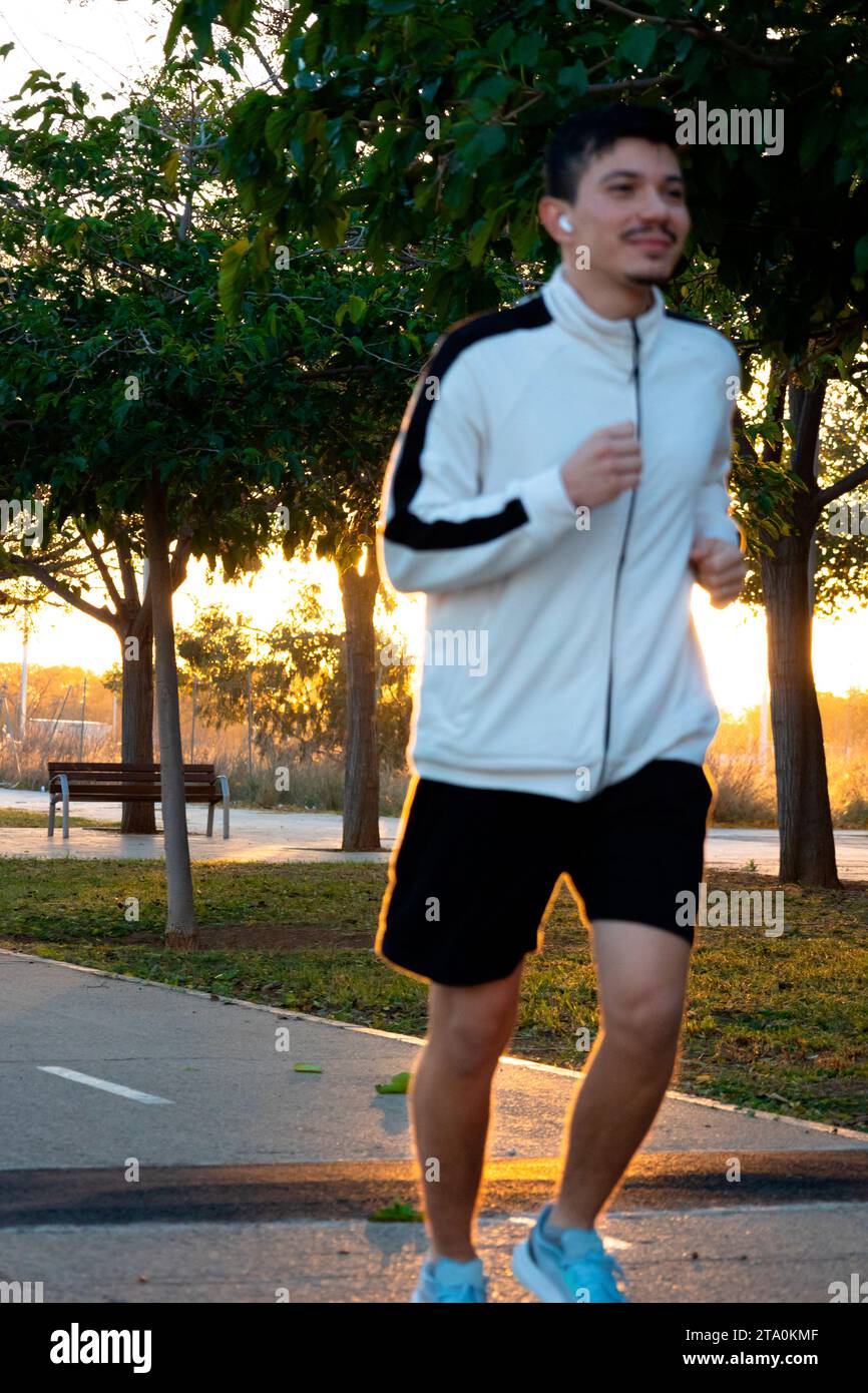 blur of young sportsman running on a morning with the golden sun rising ...