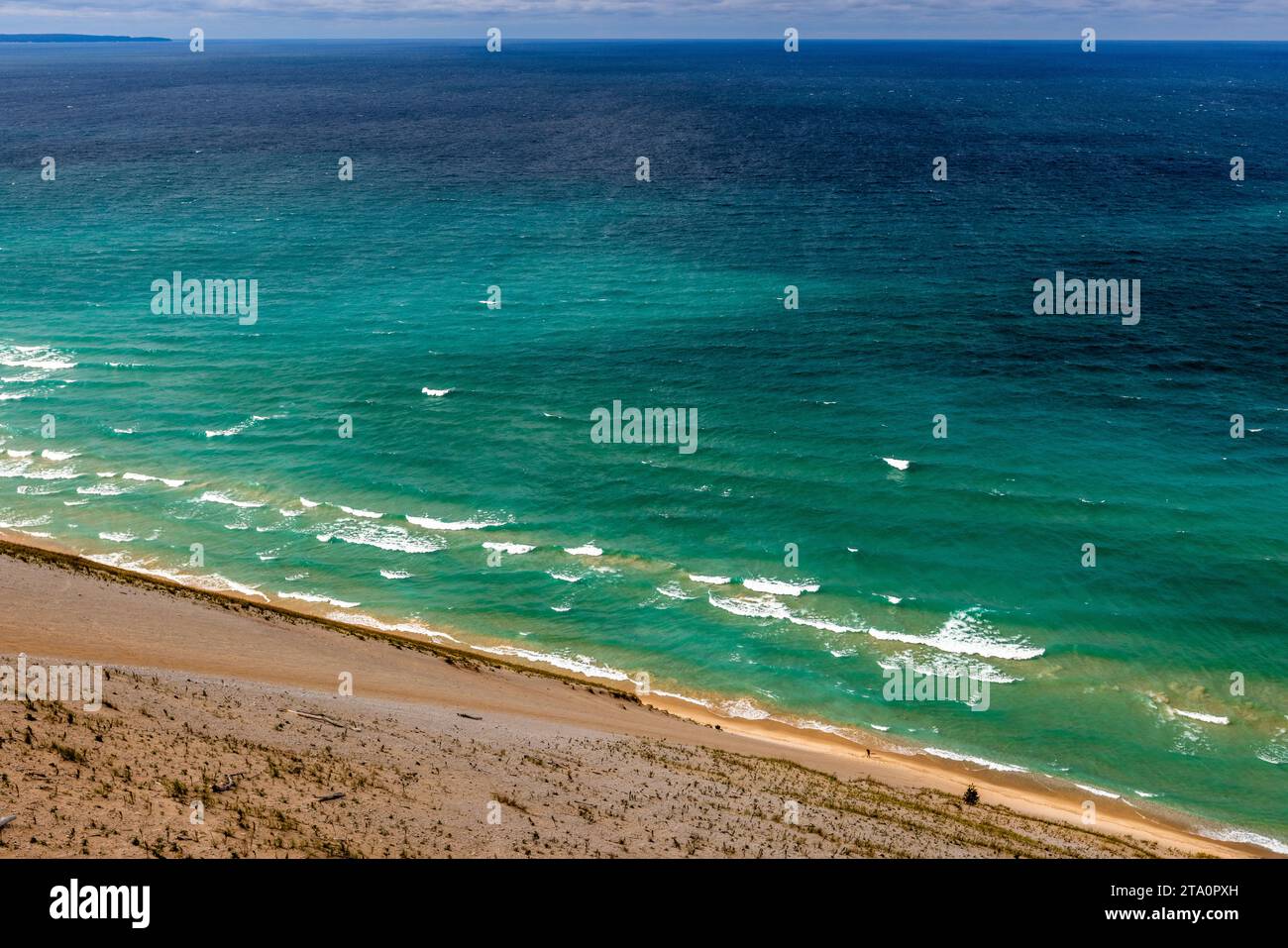 View from a steep sand dune down to a stretch of beach on Lake Michigan ...