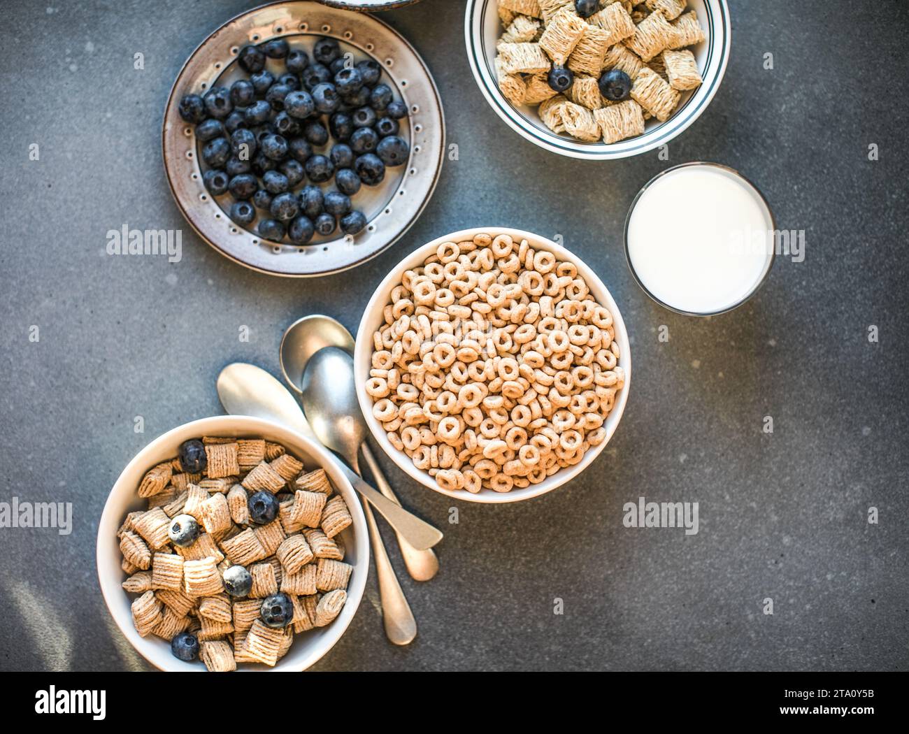 Variety of breakfast whole grain cereals and muesli in bowls on a light ...
