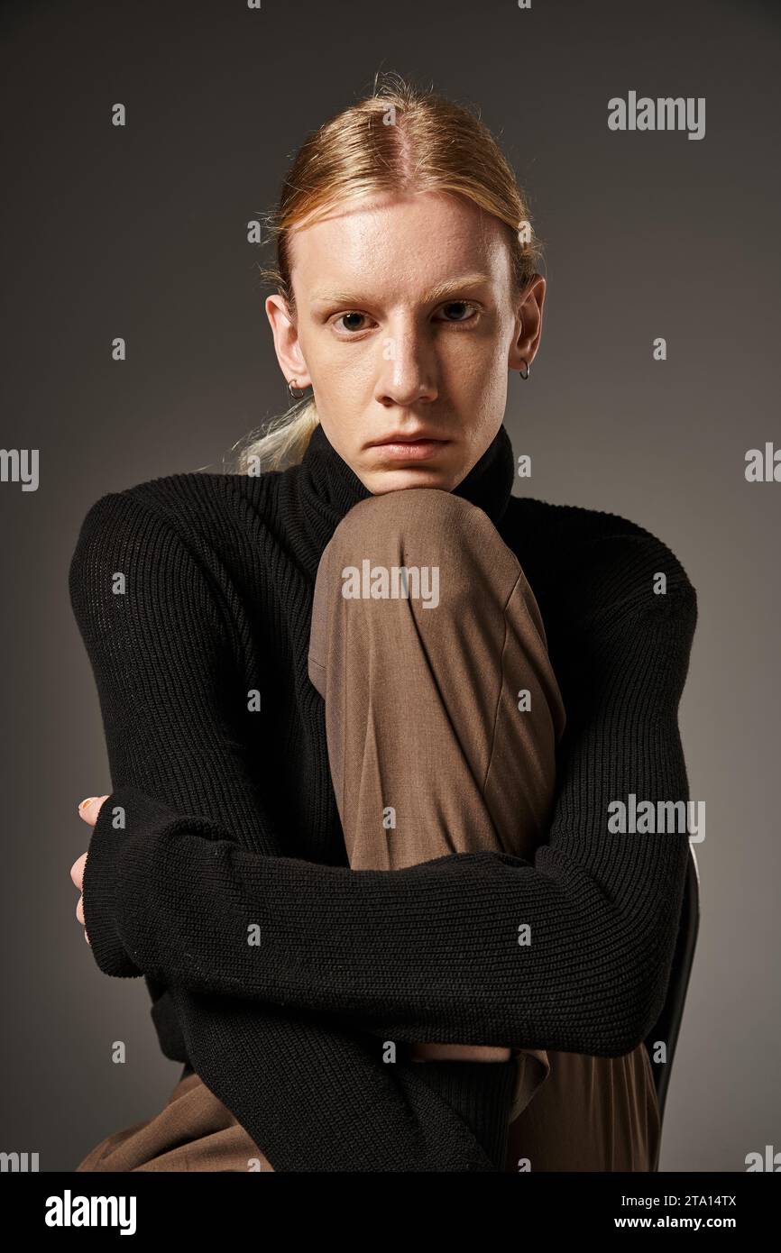 young attractive non binary person with ponytail and black turtleneck ...