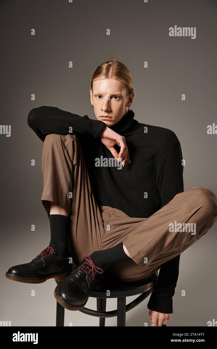 vertical shot of young non binary model in stylish attire posing on ...