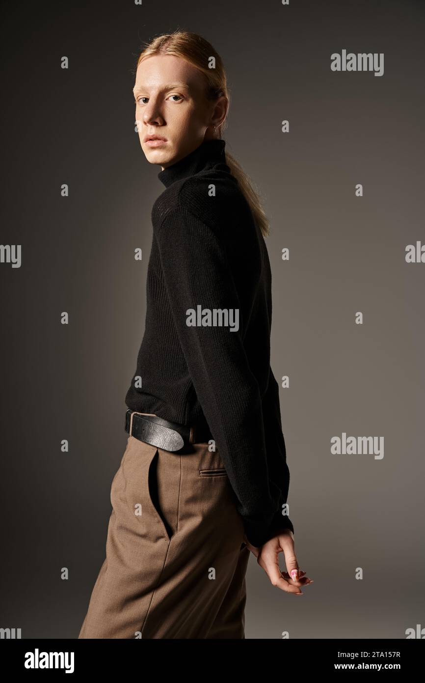 good looking young non binary model in black turtleneck turning head ...
