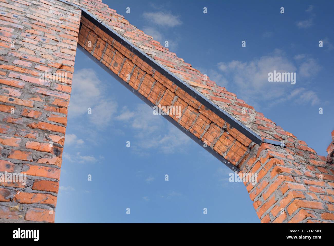 Window, door metal lintel with iron bar on brick unfinished building ...