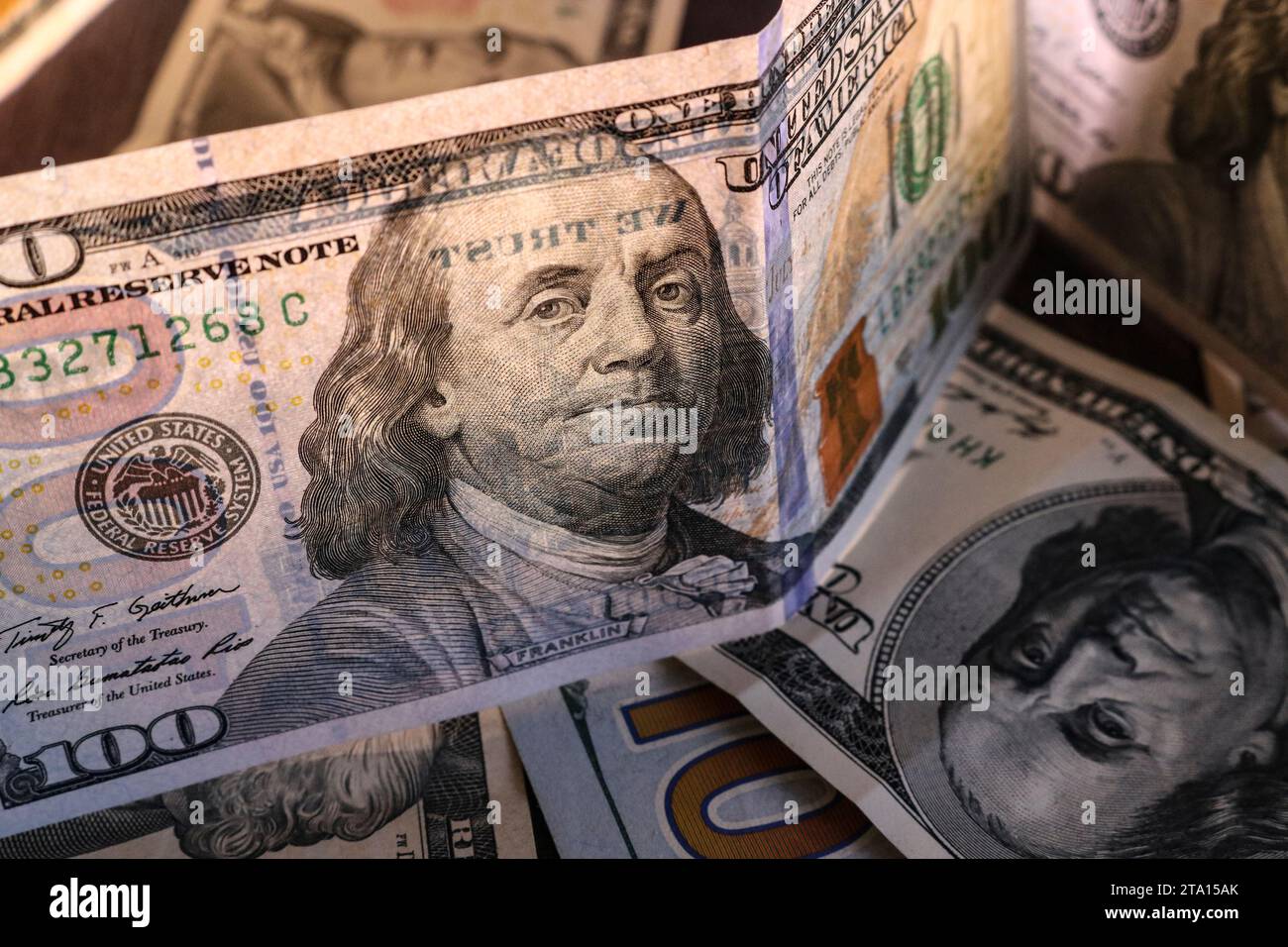 One hundred dollar bills on a dark table in backlight. Finance and ...