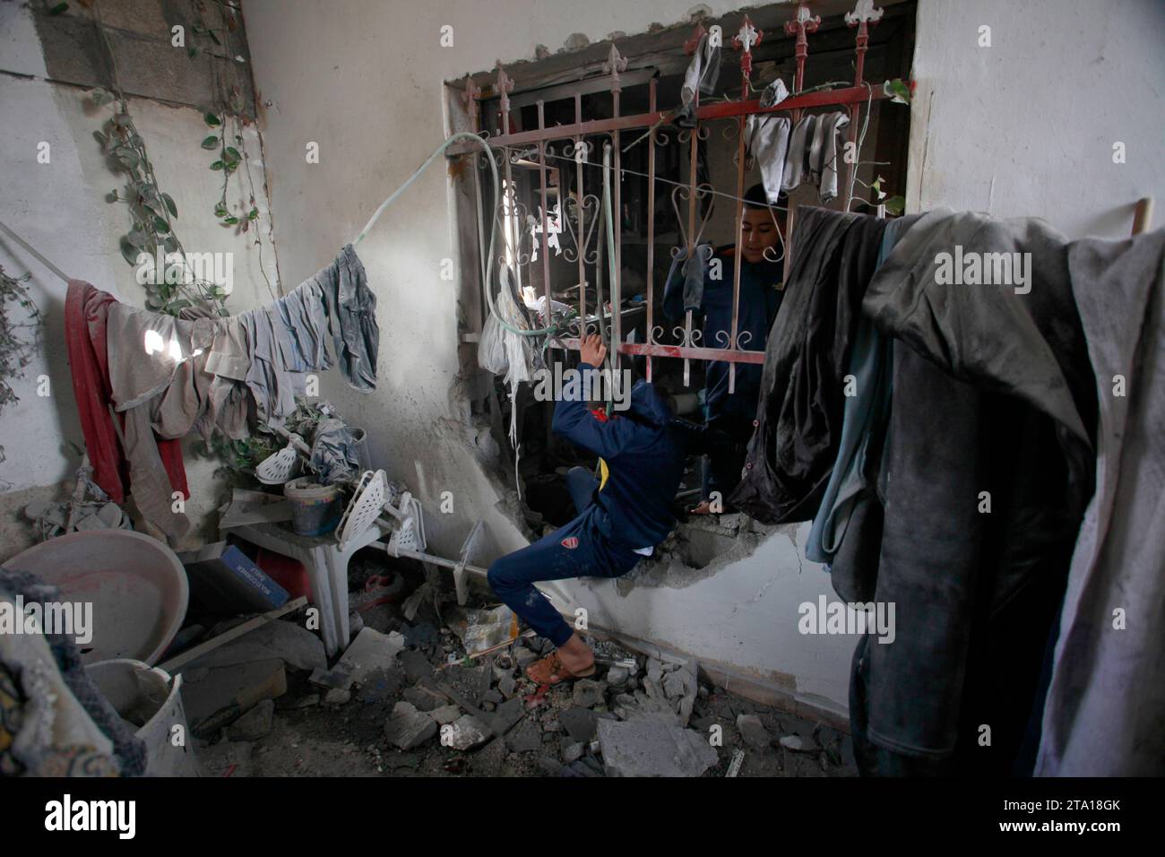 People inspect a destroyed house by a rocket launcher during a raid ...