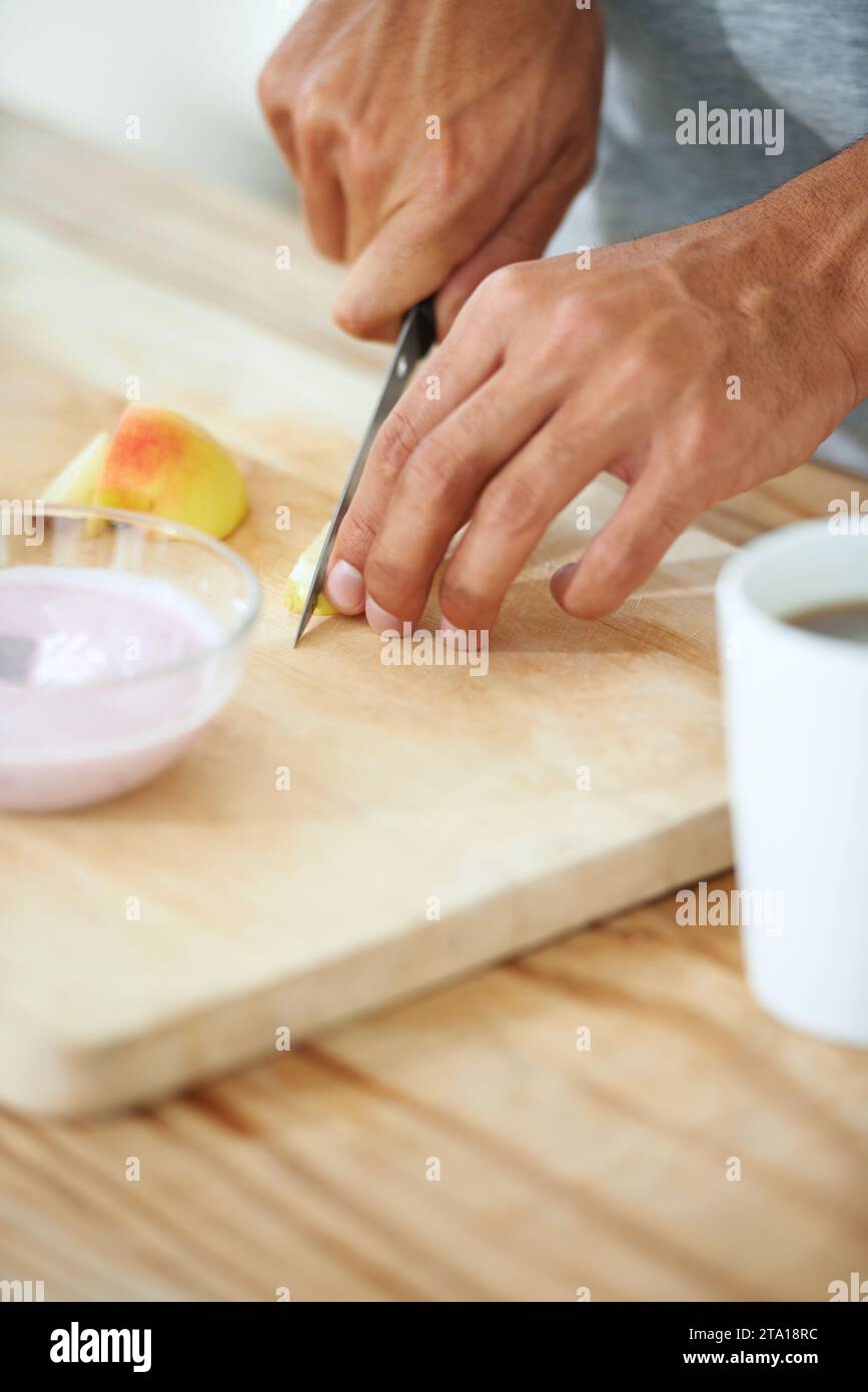 Hands, knife and fruit cutting in morning breakfast or diet nutrition ...