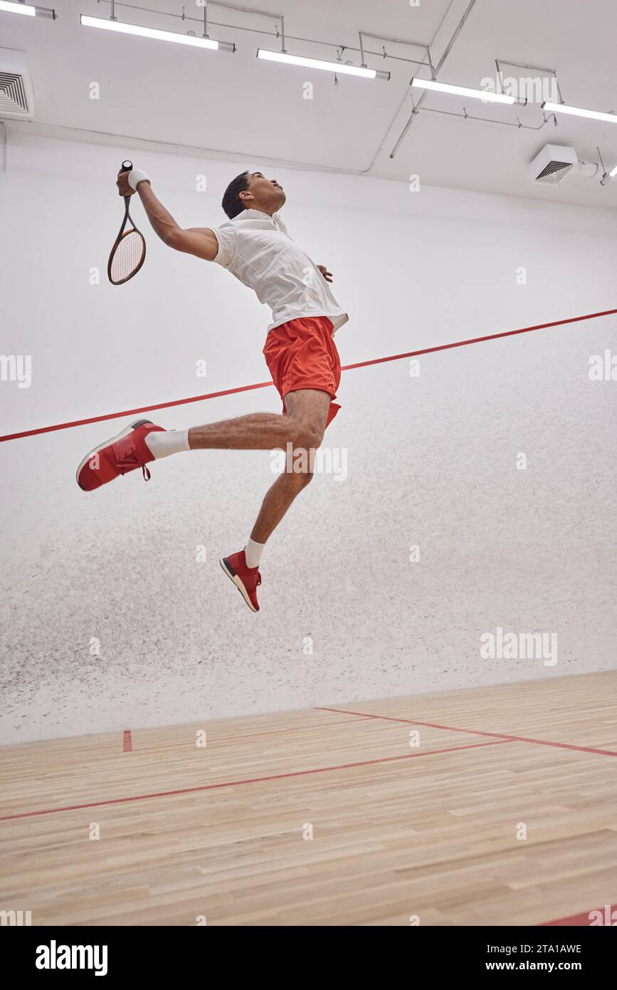 motion shot, motivated african american player holding racquet while ...