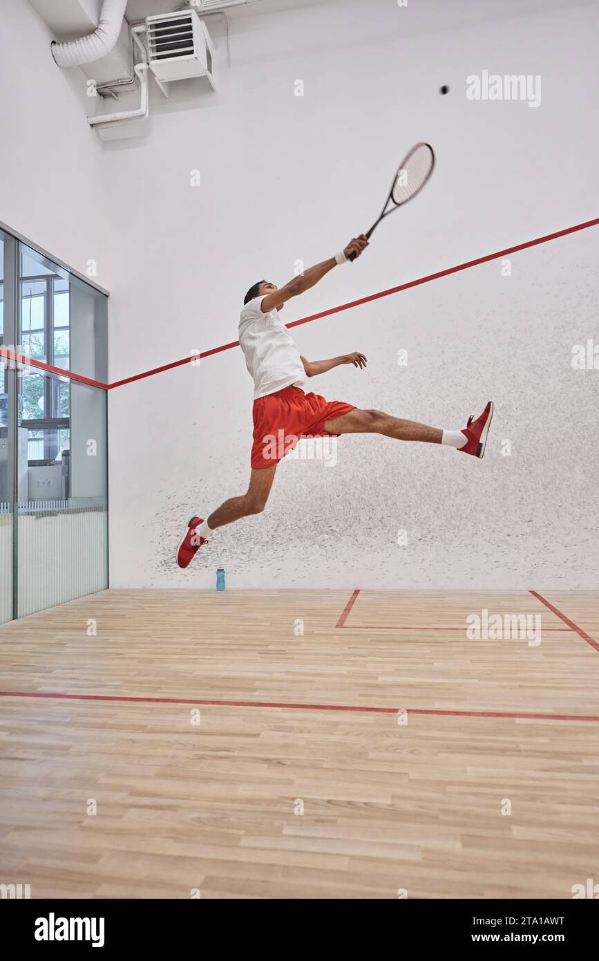 motion shot, active african american player holding racquet while ...