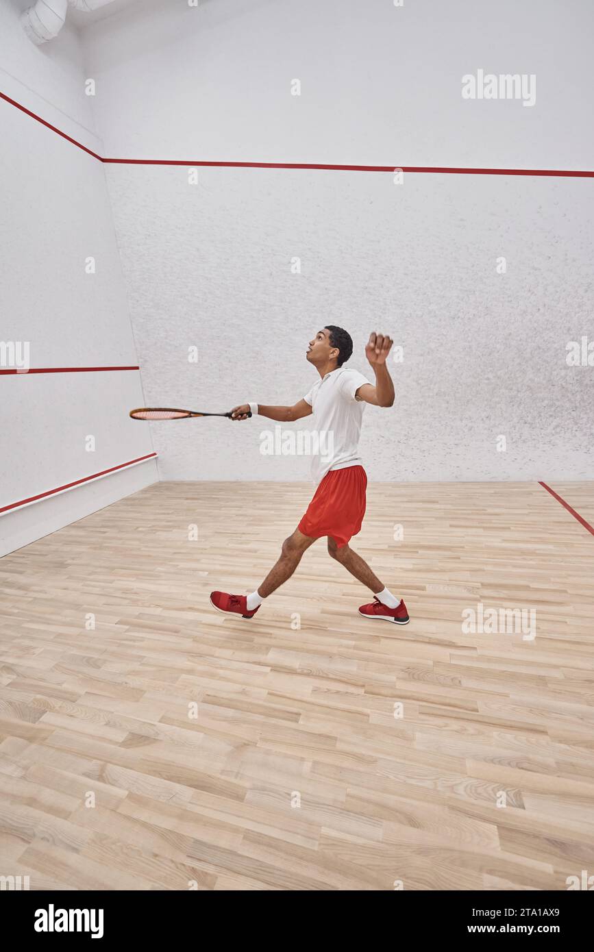 motion shot, energetic african american sportsman with racquet playing ...