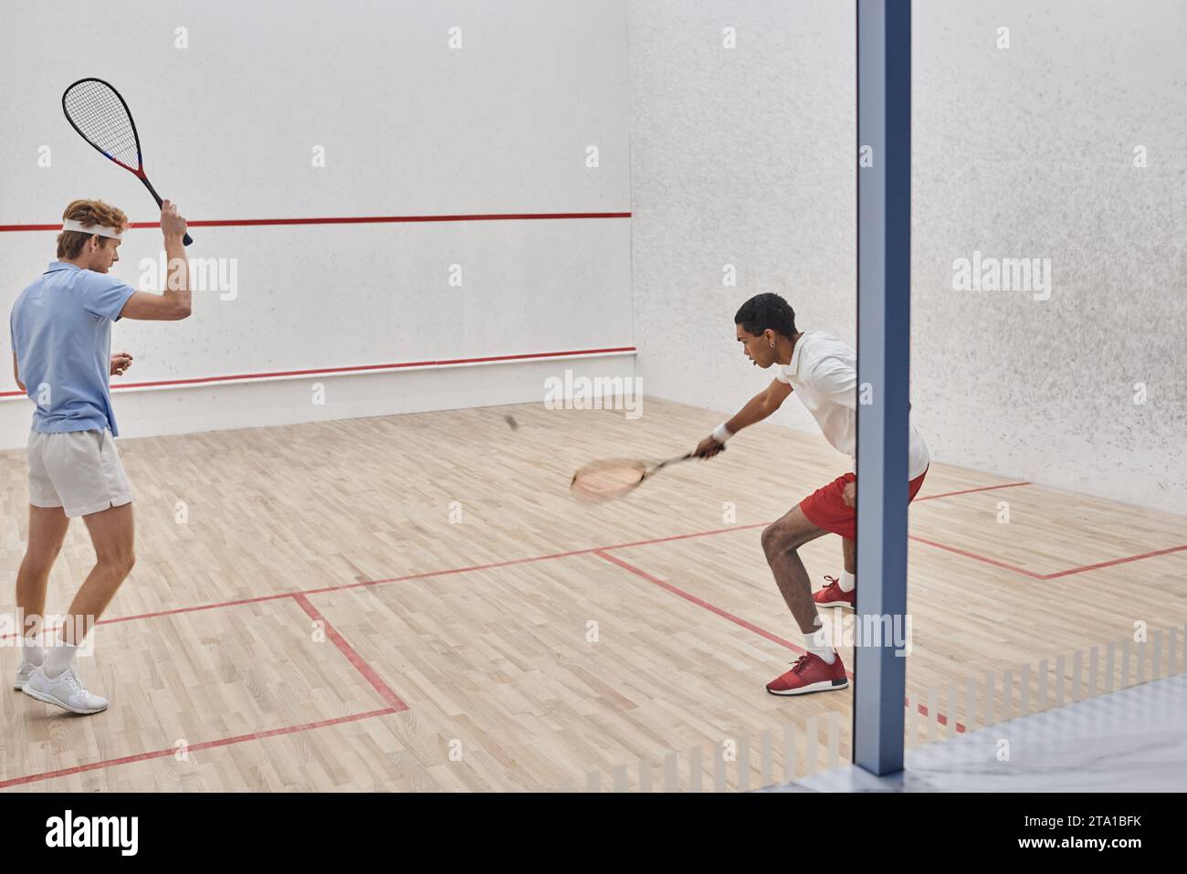 multicultural friends in sportswear playing together inside of squash ...