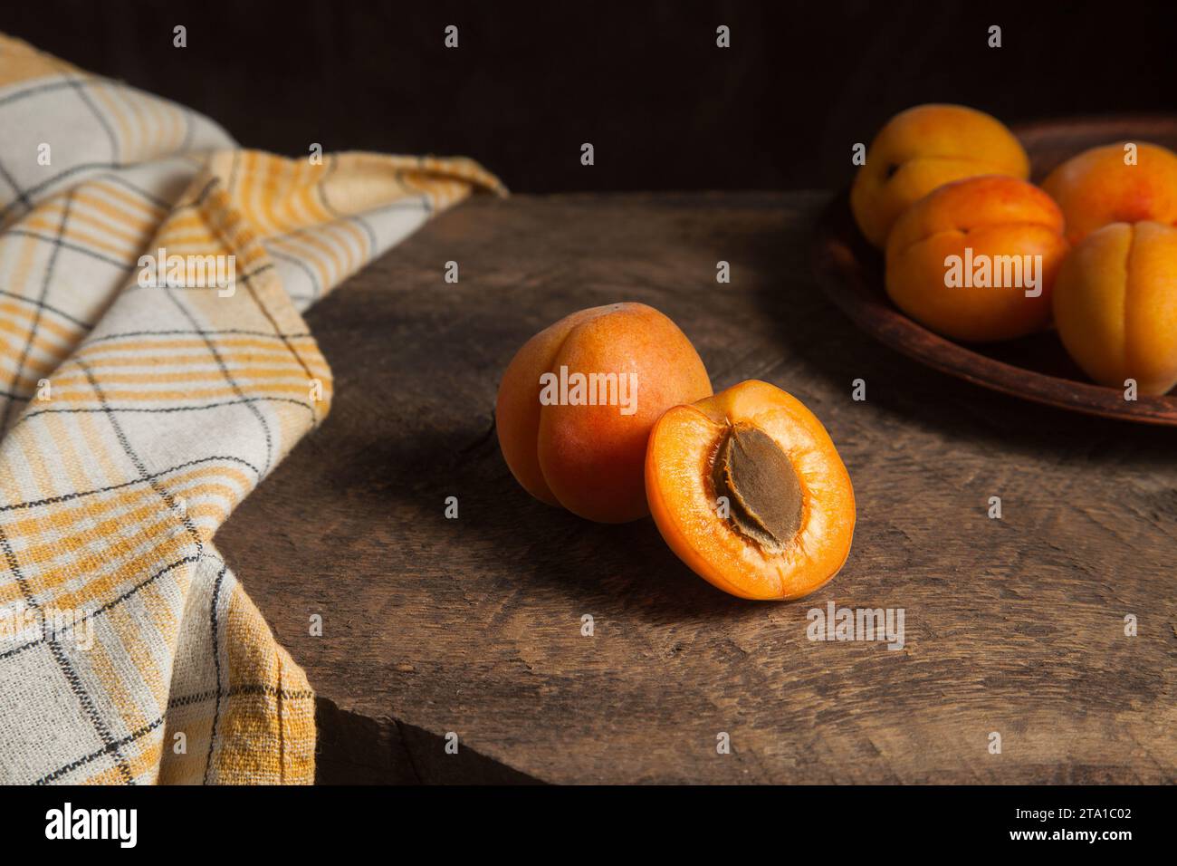 Whole and half of apricot fruits with clay plate with fruits on ...