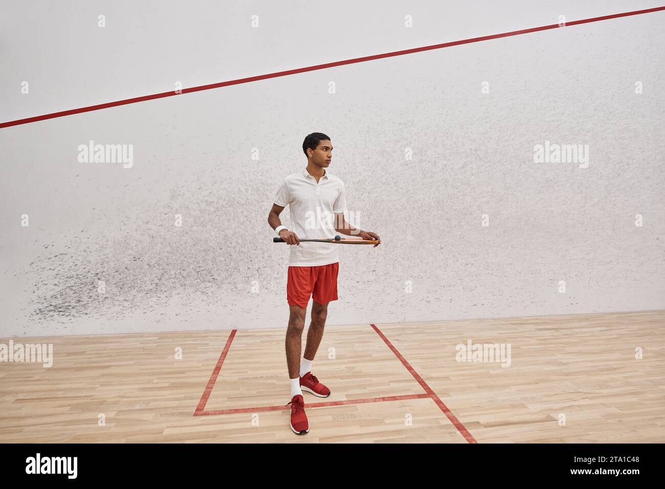 african american sportsman holding squash ball and racquet while ...