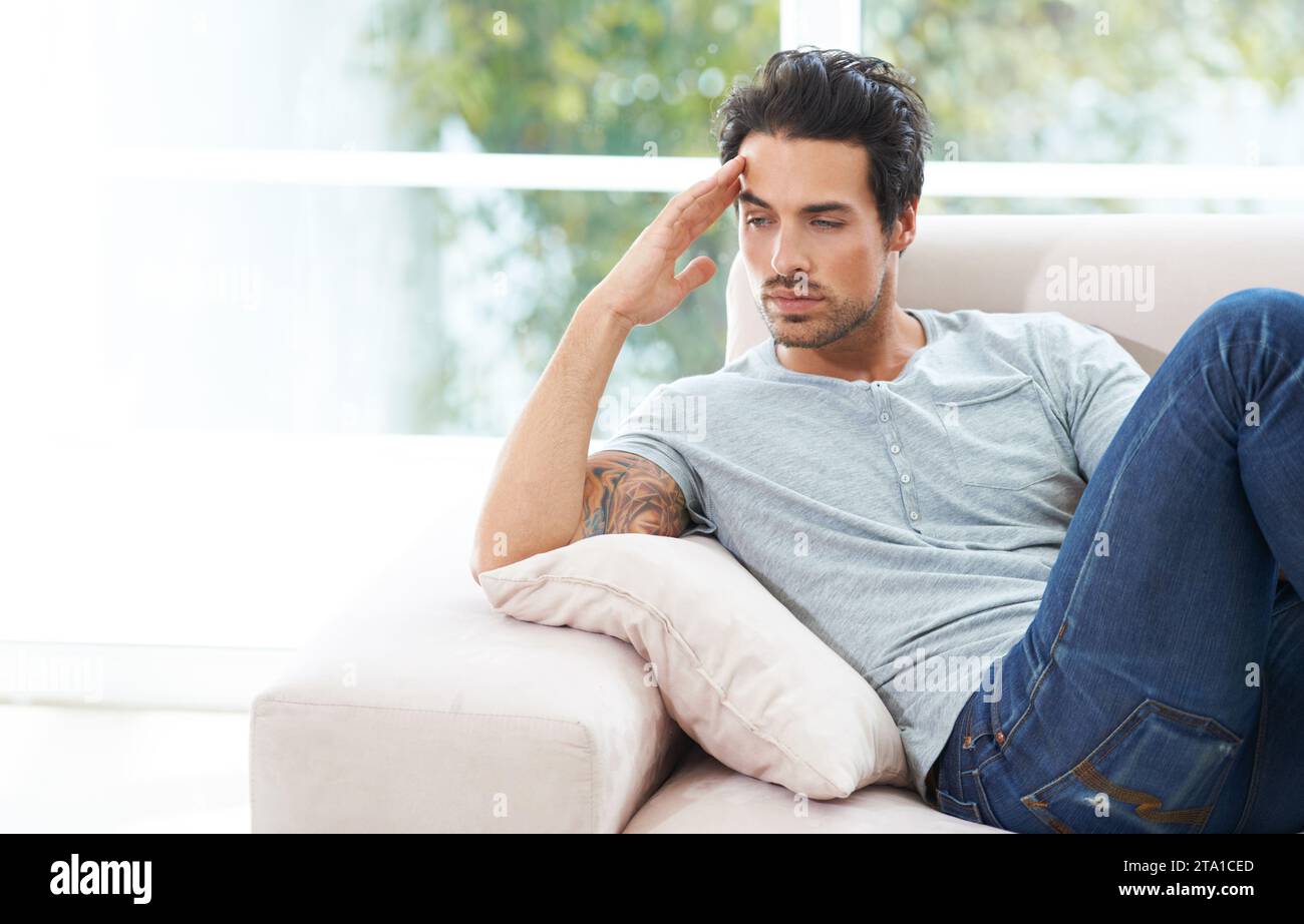 Man, thinking and sofa for unhappy in home or lonely grief mourning ...