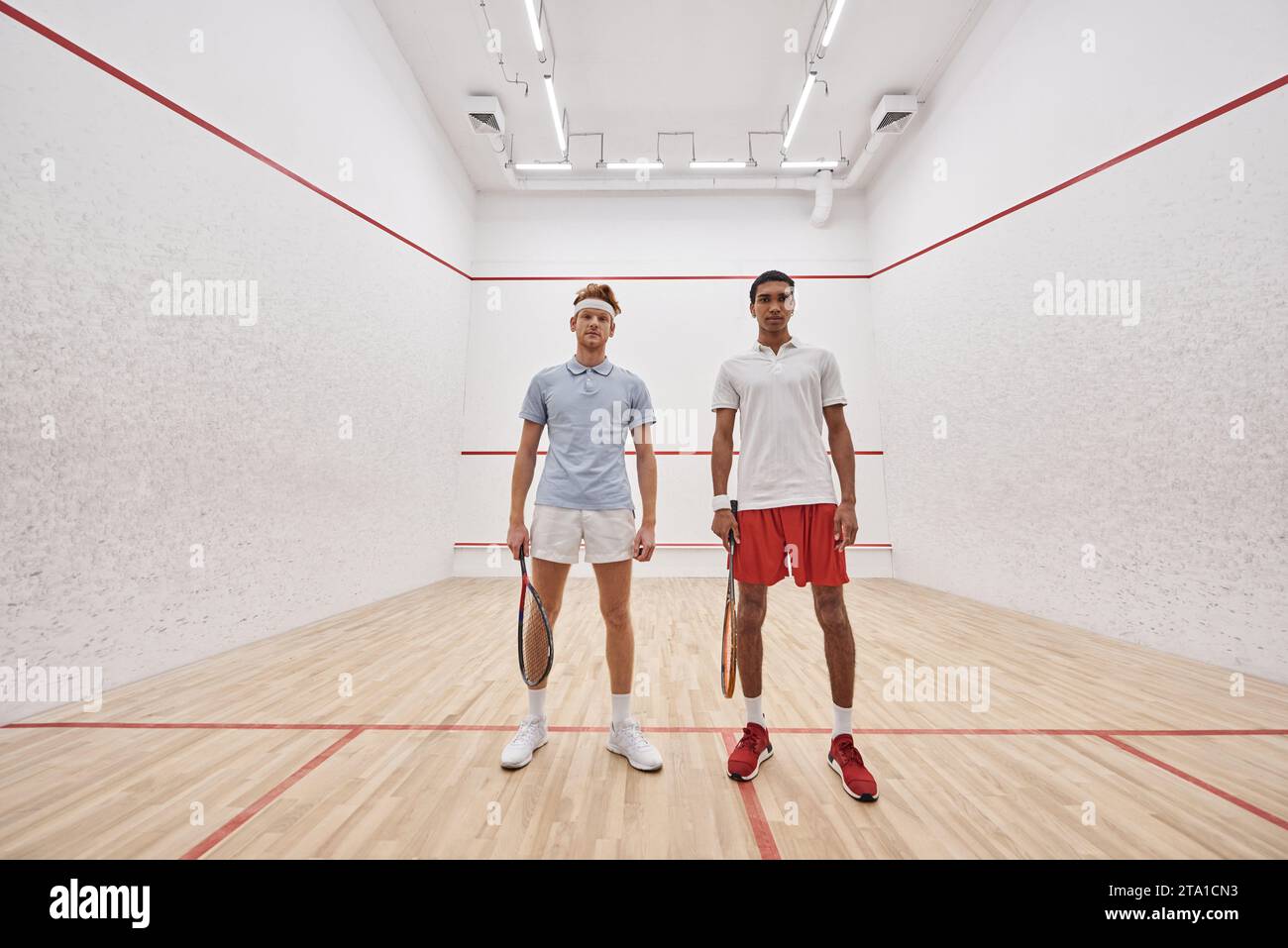 young interracial male friends in sportswear looking at camera and ...