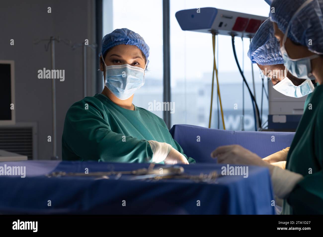 Diverse male and female surgeons with face masks doing surgery in ...