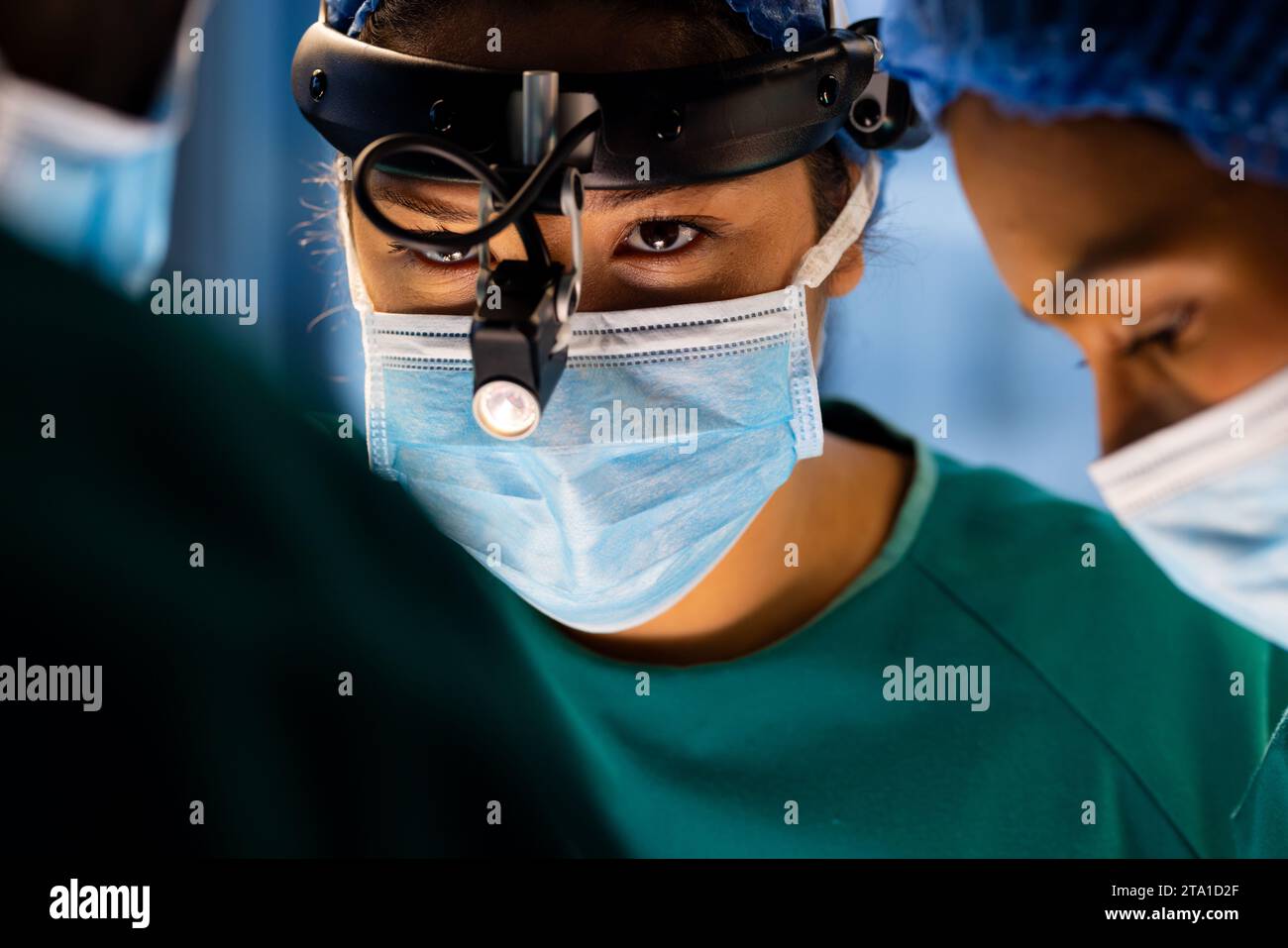 Diverse male and female surgeons with face masks doing surgery in ...