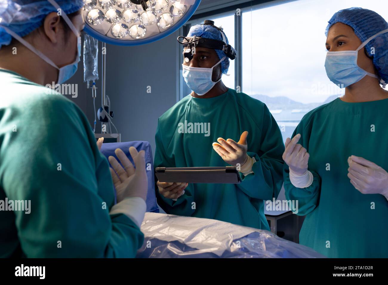 Diverse male and female surgeons with face masks talking and using ...