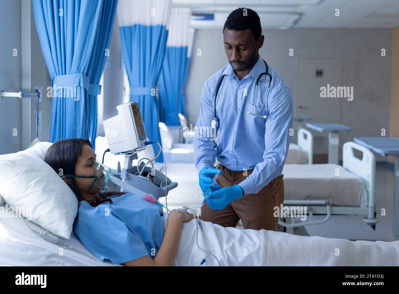 Diverse male doctor filling iv drip on female patient's hand in bed in ...