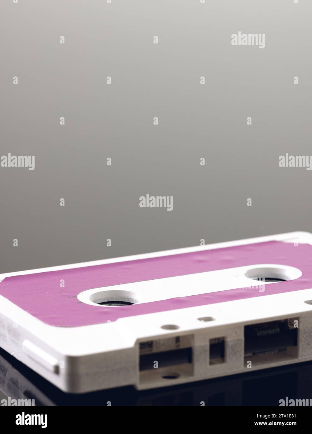 Close up of white and pink cassette tape with copy space on grey ...