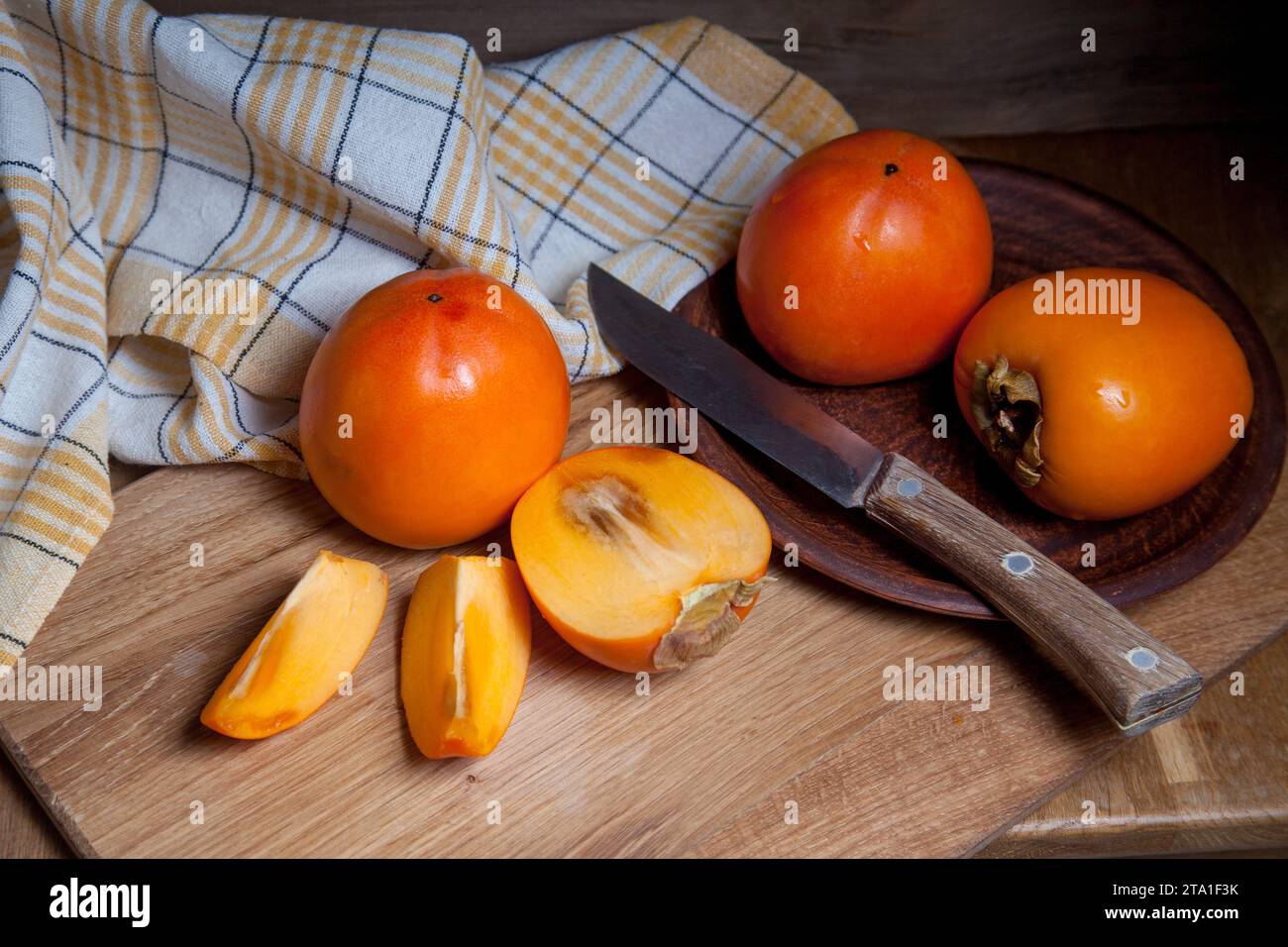 Composition of ripe delicious whole persimmon fruits, half and sliced ...