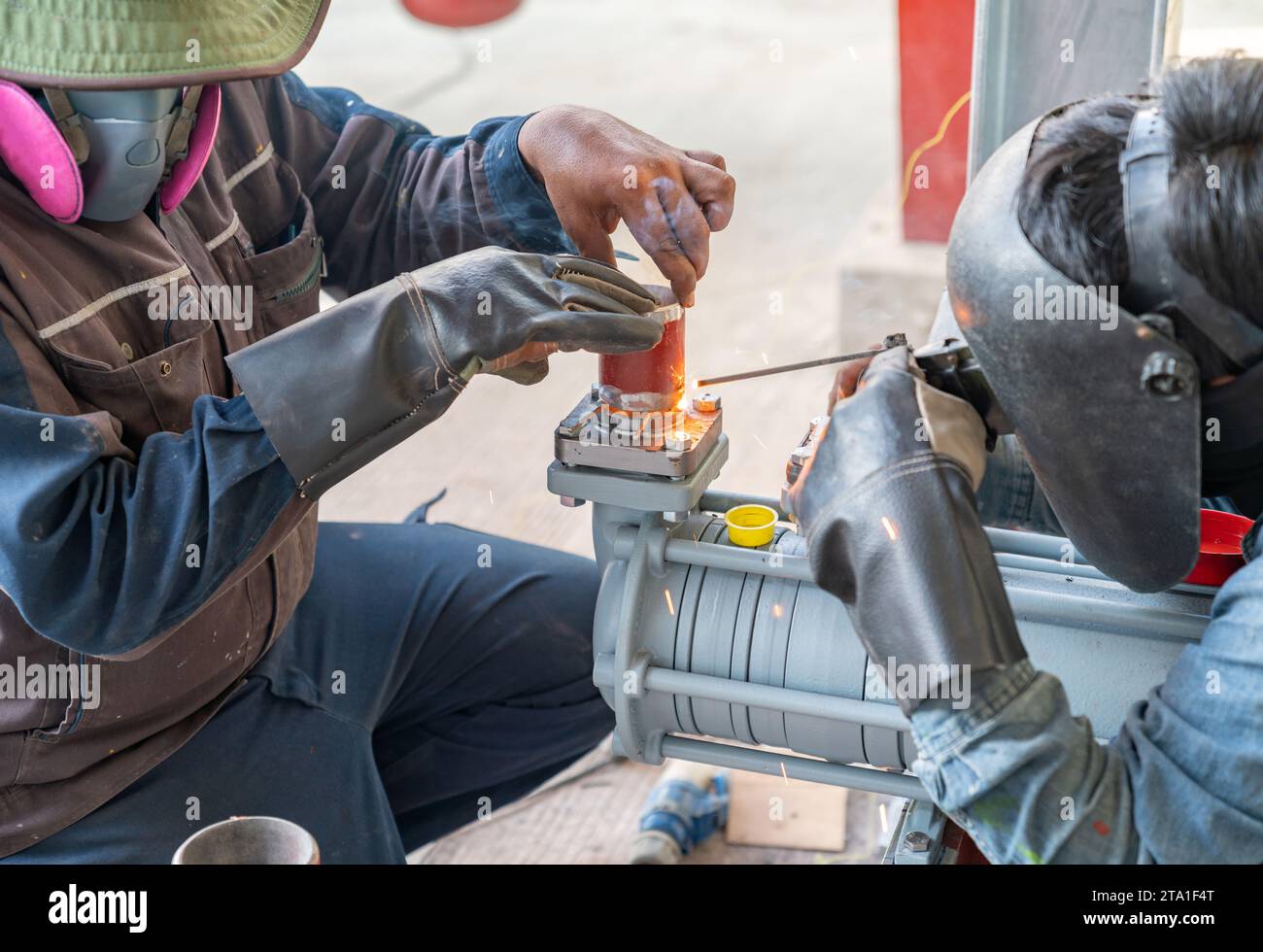 The welder is welding the steel pipe. The welder wears protective ...