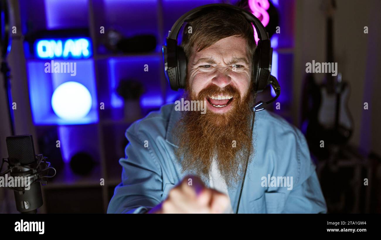 Cheerful young redhead streamer celebrates epic win. man playing video ...