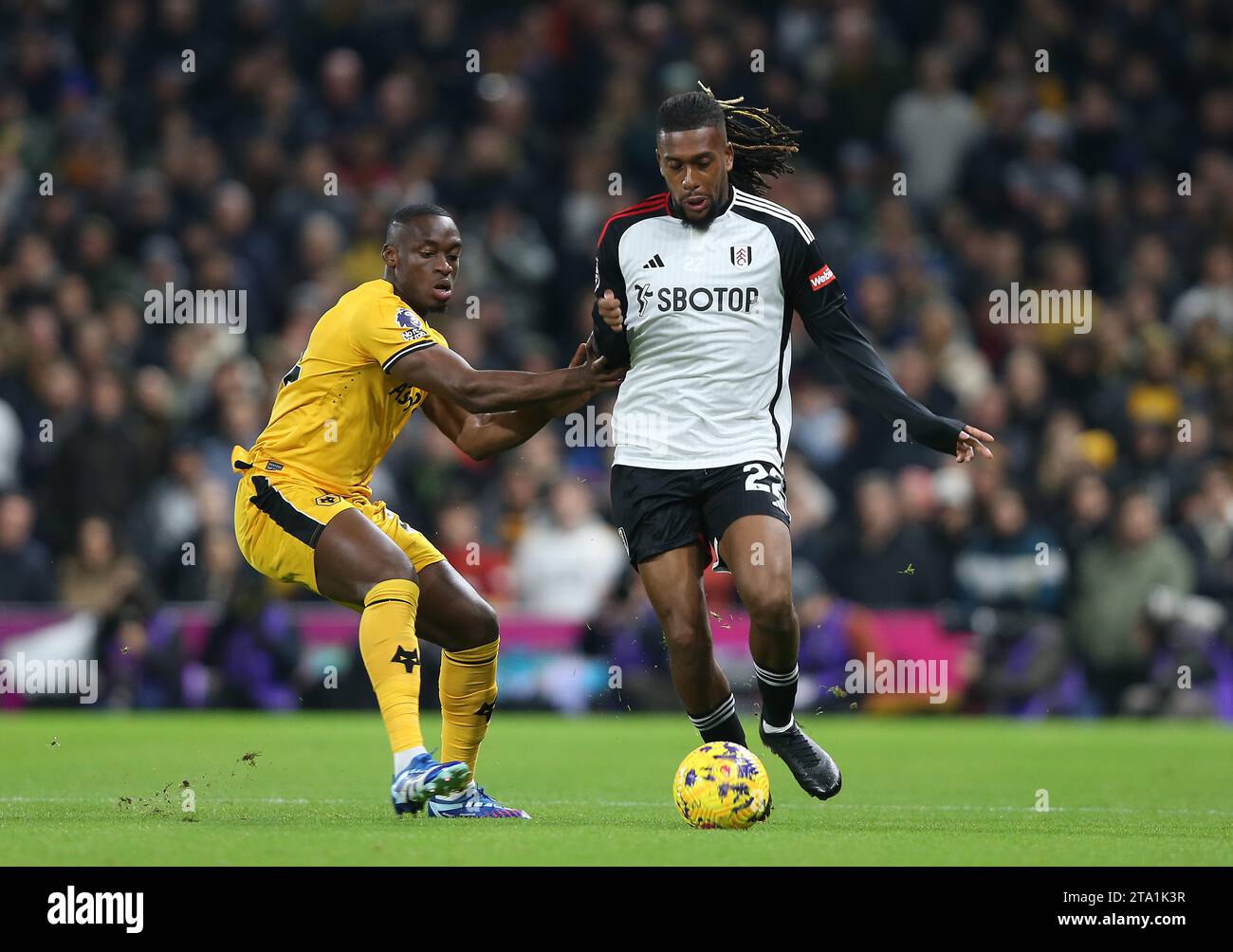 Alex Iwobi of Fulham battles Toti Gomes of Wolverhampton Wanderers ...