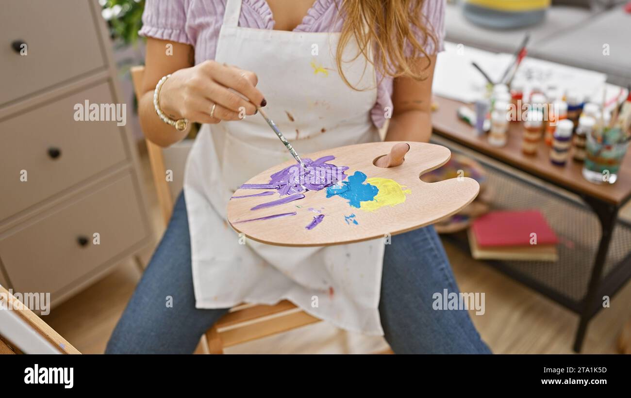 Talented woman artist passionately mixing colors on her palette, hands ...