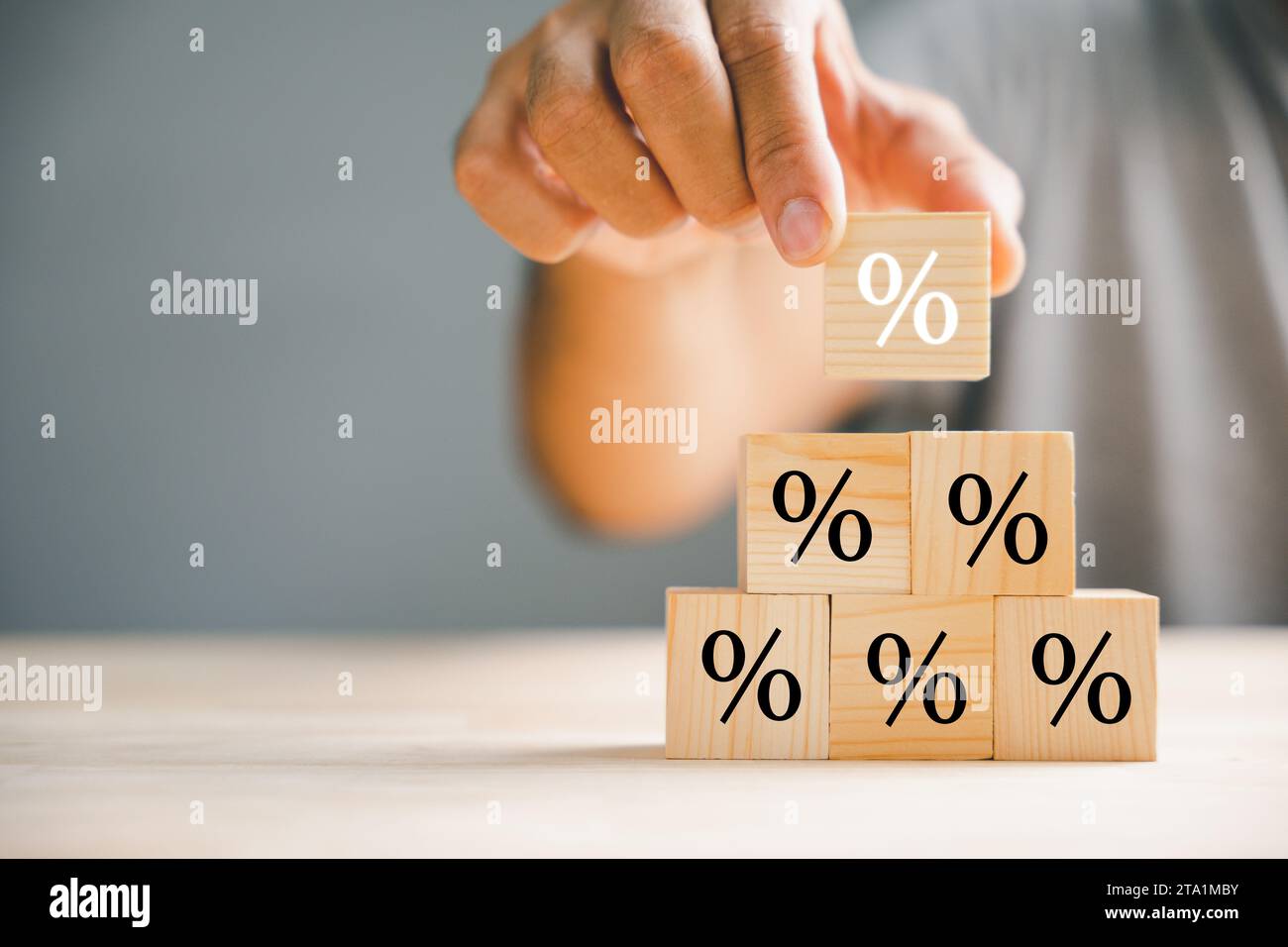 Businessman's hand arranging a wood cube block with a percentage symbol ...
