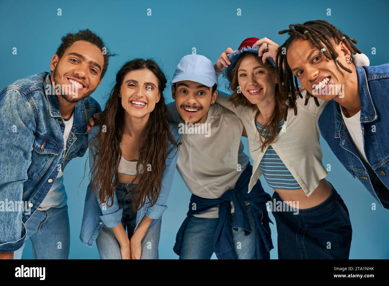cheerful multiethnic friends in trendy street wear smiling at camera om ...