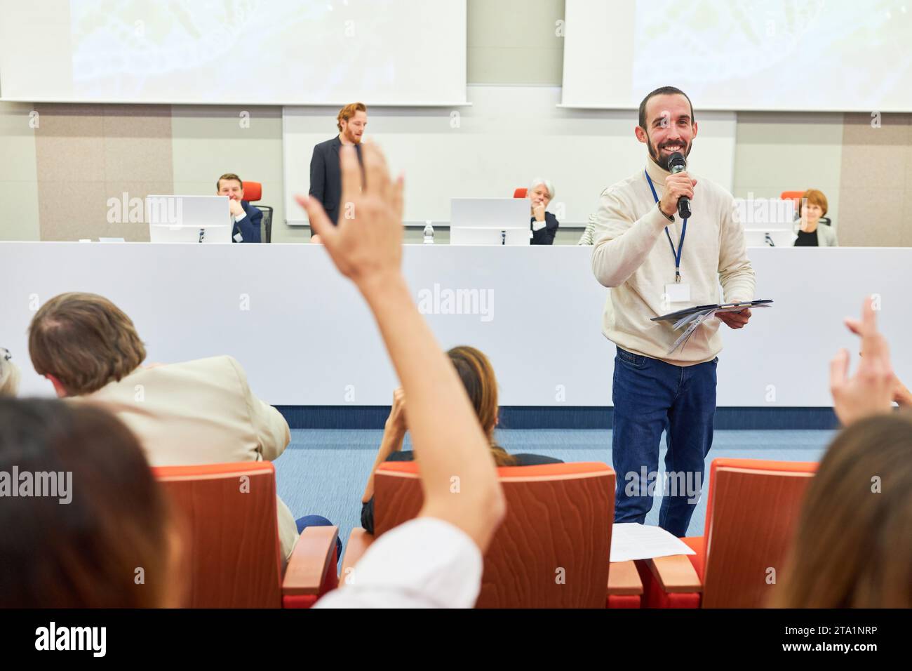 Man speaking on microphone while discussing with audience during ...