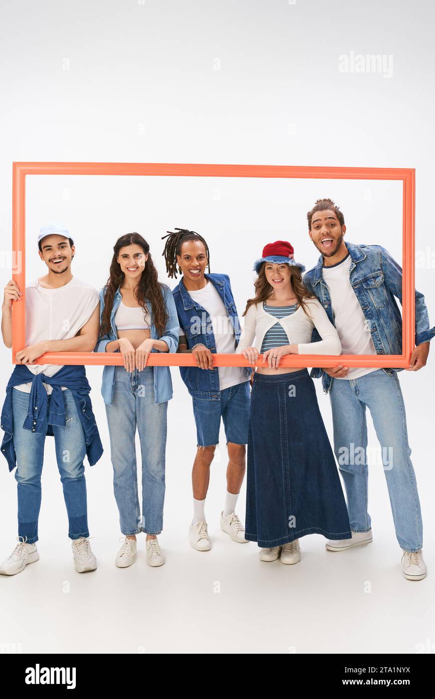 group portrait of multiethnic friends in street wear standing with ...