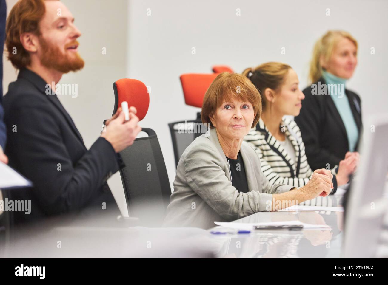 Orator explaining while standing by professionals on stage in ...
