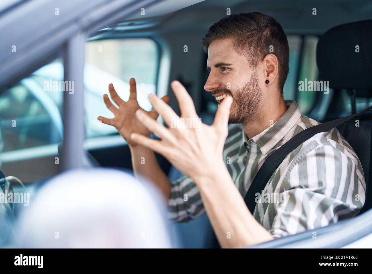 Young caucasian man sitting on car dancing at street Stock Photo - Alamy