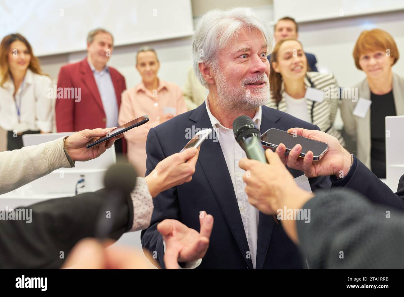 Business speaker talking to journalists with microphones and phones at ...